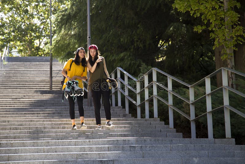 Girls Going Down the Ladder with Roller Skates and Skateboard in Hand ...