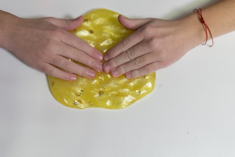 Girls Hand Playing with Yellow Shiny Slime at the Table at Home Stock ...
