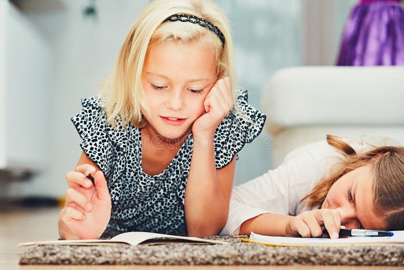 Girls writing homework stock photo. Image of carpet - 100385762