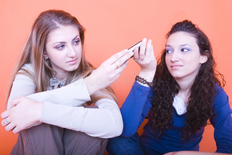 Girls passing a cell phone stock photo. Image of hand - 2484672