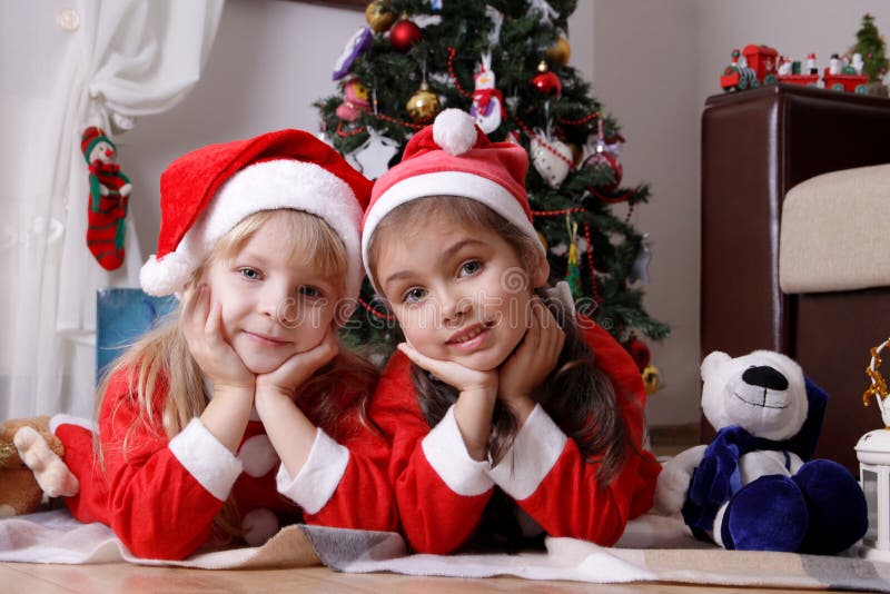 Girls Santa Helpers Lying Under Christmas Tree Stock Image - Image of ...