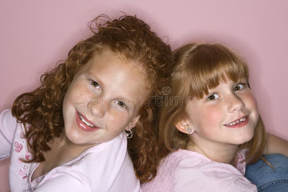 Girls Sitting Back To Back. Stock Photo - Image of smiling, redhead ...