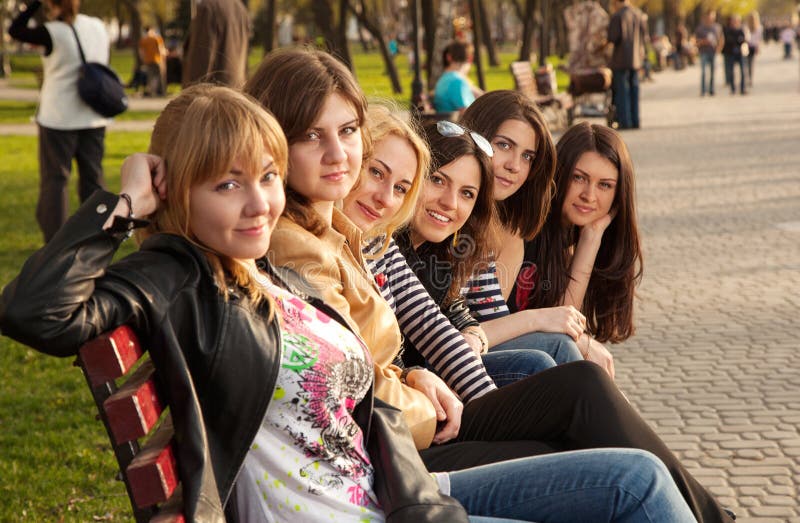 Girls sitting on a bench stock photo. Image of laughing - 25752890