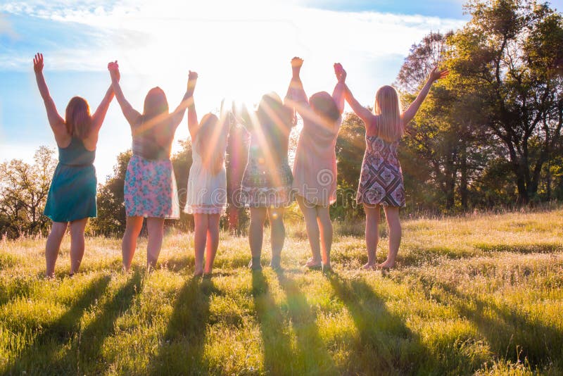 Girls Standing with Arms Raised and Sunlight Overhead Stock Image ...