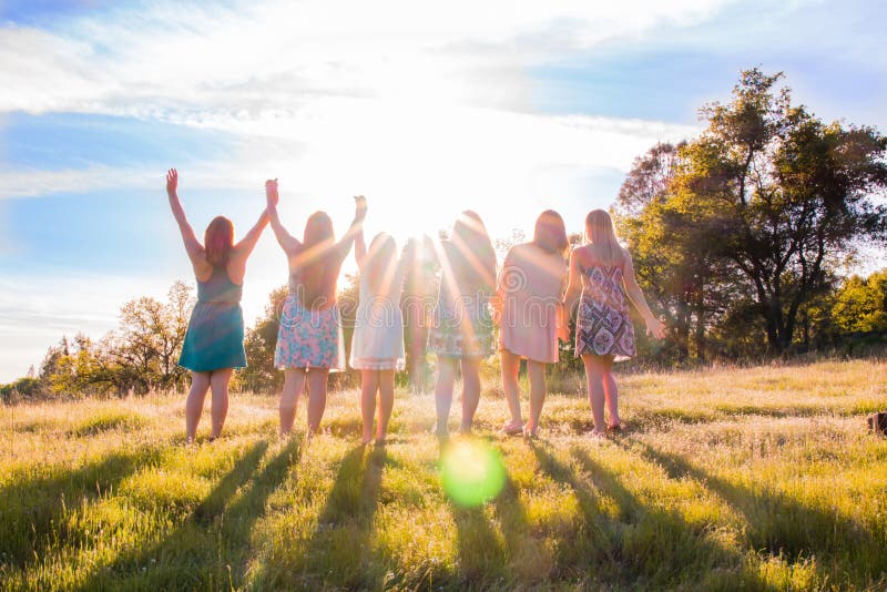 Girls Standing with Arms Raised and Sunlight Overhead Stock Image ...