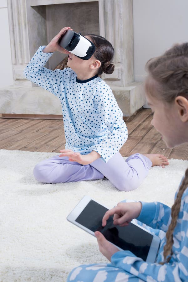 Girls with Virtual Reality Headset and Digital Tablet Sitting on Carpet ...