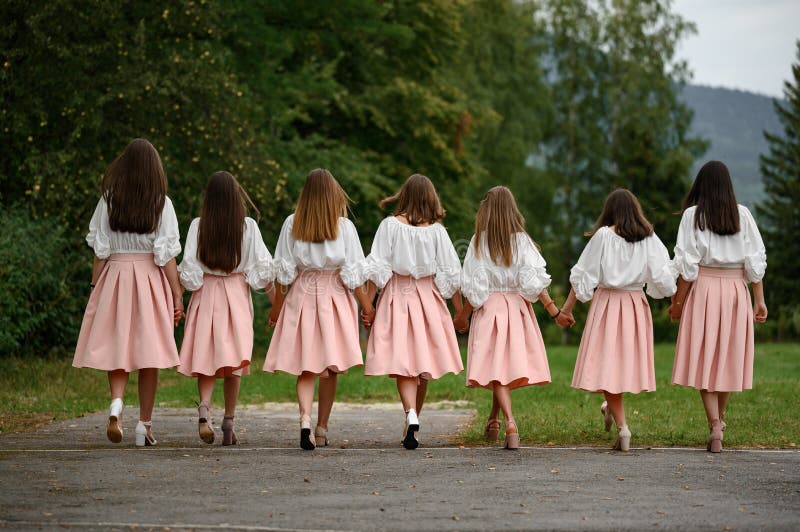 The Girls Walk Forward on the Grass in Identical Blouses and Skirts ...