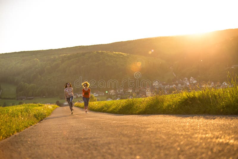 Girls Walking on a Raod at Sunset Stock Image - Image of face, clothing ...