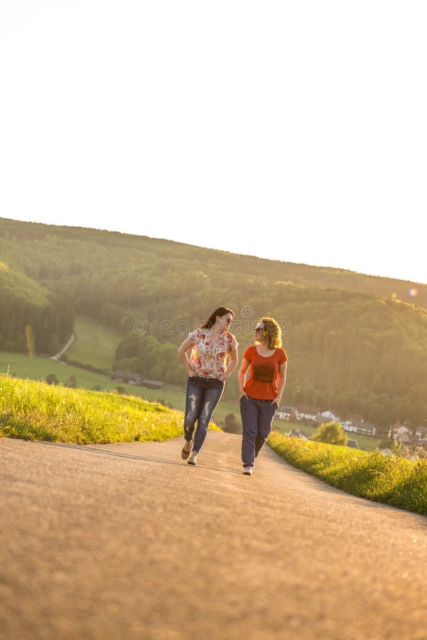 Girls Walking on a Raod at Sunset Stock Photo - Image of happiness ...
