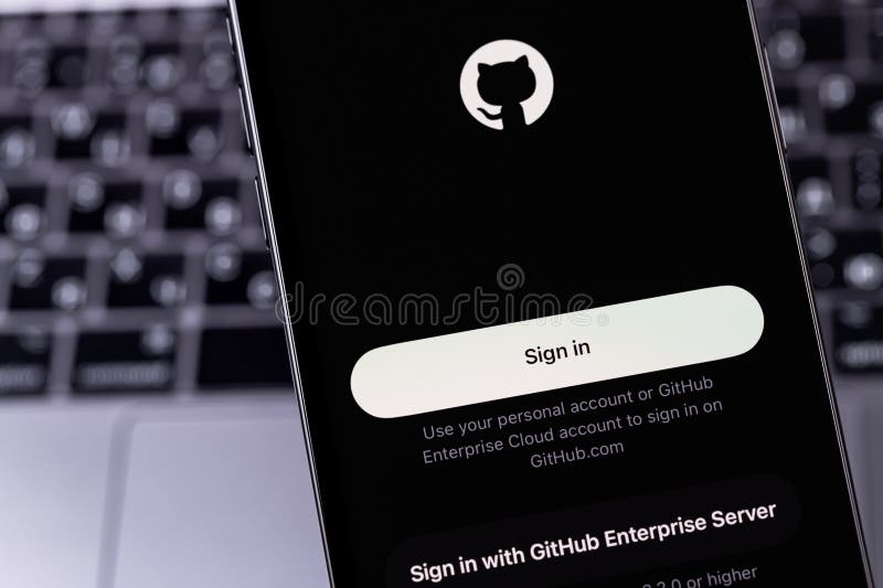 GitHub Logo Mobile App on a Screen Smartphone and Notebook Closeup. GitHub is the Largest Web ...