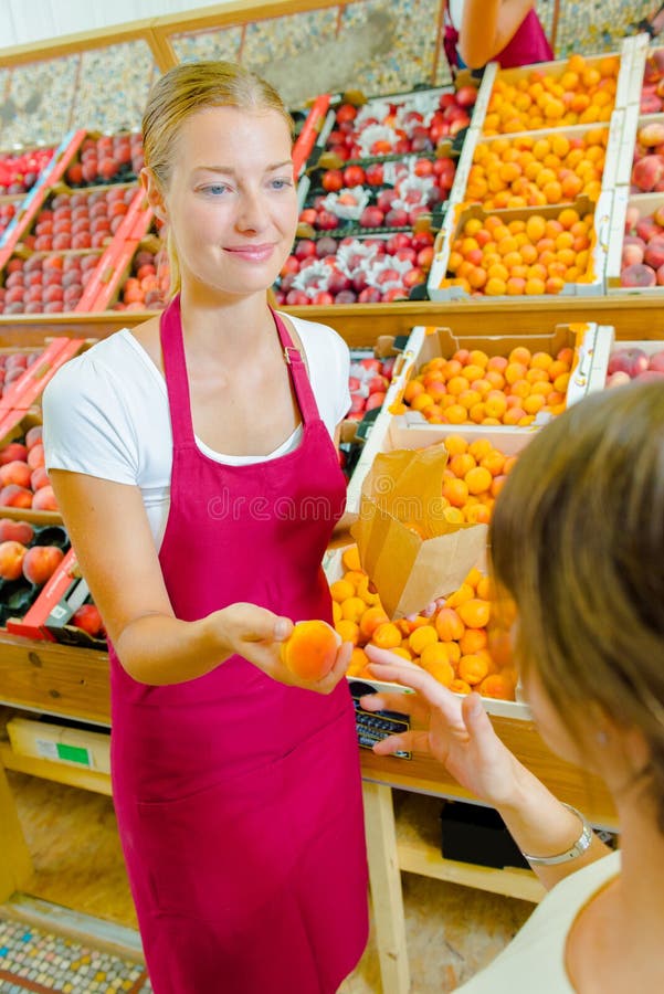 Giving orange to customer stock photo. Image of service - 95175344