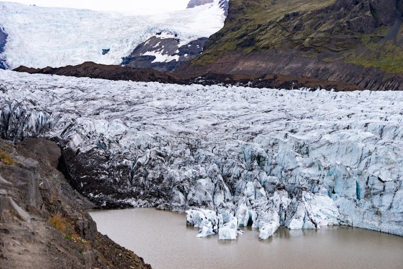 Glacier with Ash in the Ice with Melted Water and Icelandic Landscape ...