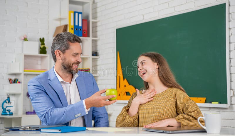 Glad Child in Classroom with Tutor Sharing Apple Stock Photo - Image of ...