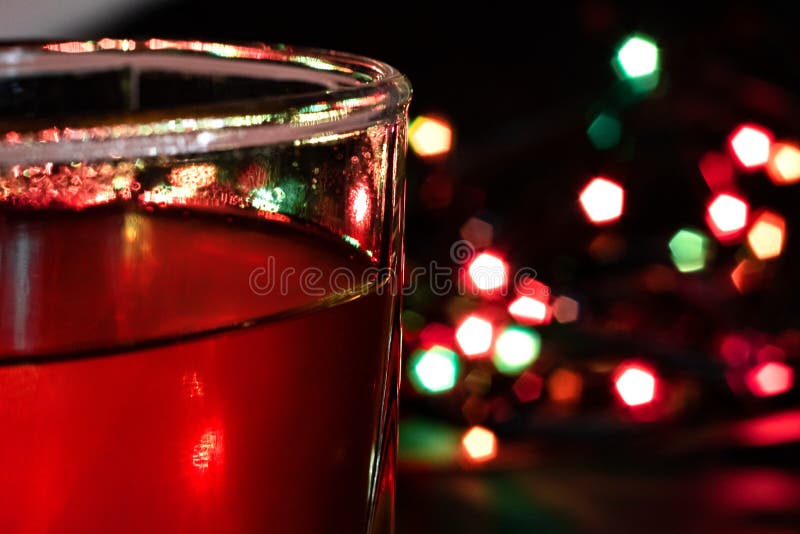 A Glass with an Alcoholic Drink Against a Background of Colored Lights ...
