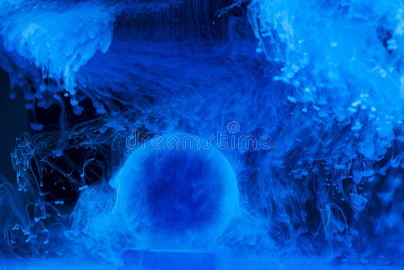 Glass Ball with Blue Paint Splash Underwater and on a Black Backgorund ...