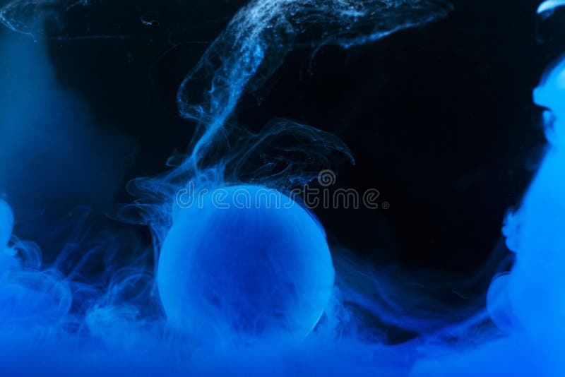 Glass Ball with Blue Paint Splash Underwater and on a Black Backgorund ...