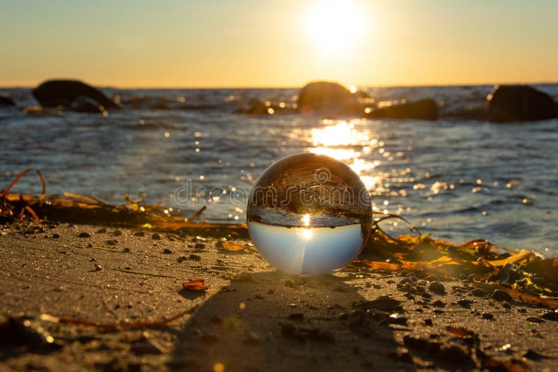 The Beach and the Sea are Reflected in a Sphere Lying in the Sand Stock ...