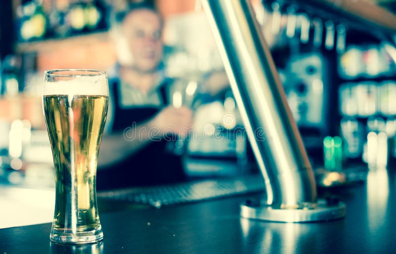 Glass of Beer on Bar Counter Against Background of Friendly Bart Stock ...
