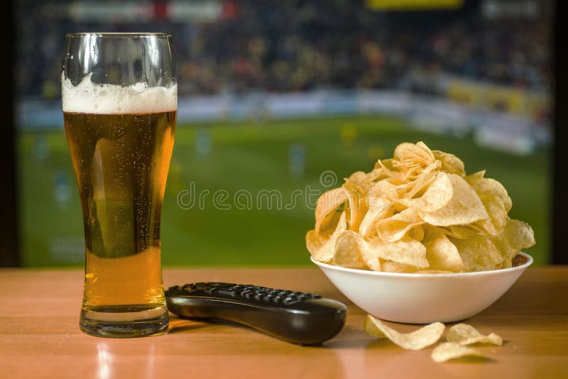 A Glass of Beer, a Bowl of Chips and a TV Remote Control on the TV ...
