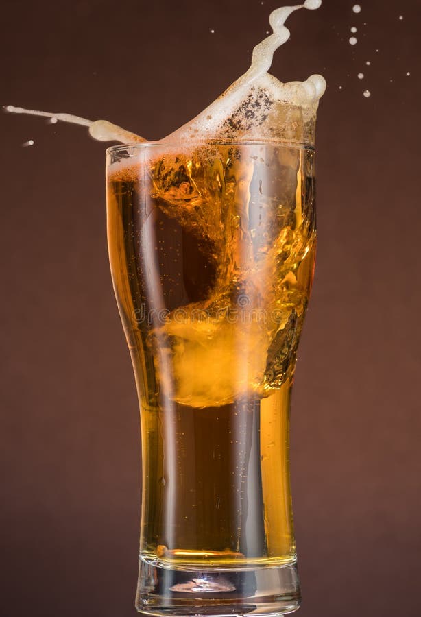 Beer in a Glass Poured from a Bottle Thrown from the Ice and Foam Stock ...