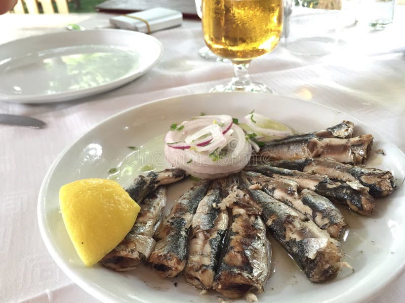Beer and sardines on table stock image. Image of plate - 99694195