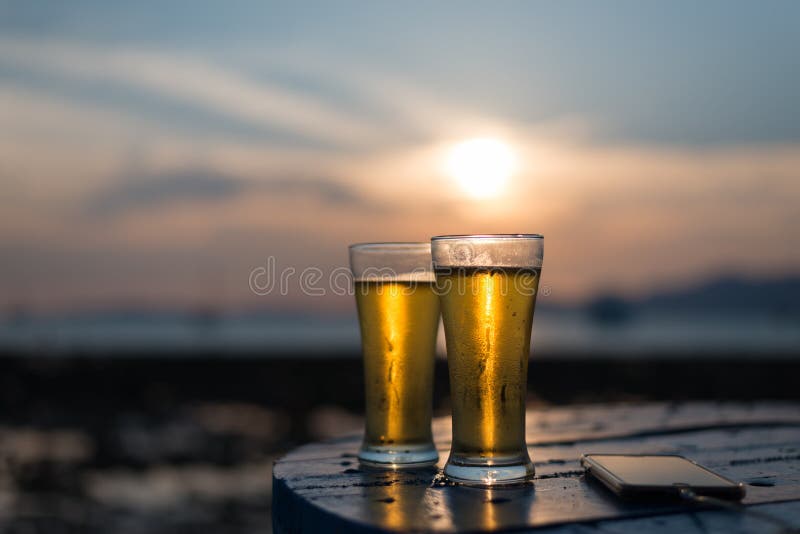 Glass of beer on a sunset stock image. Image of sand - 85585291