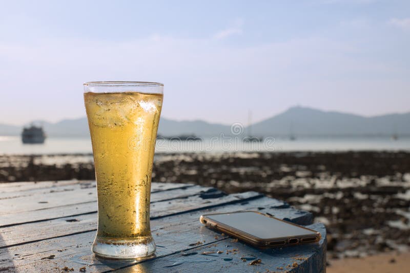 Glass of beer on a sunset stock image. Image of sand - 85585291