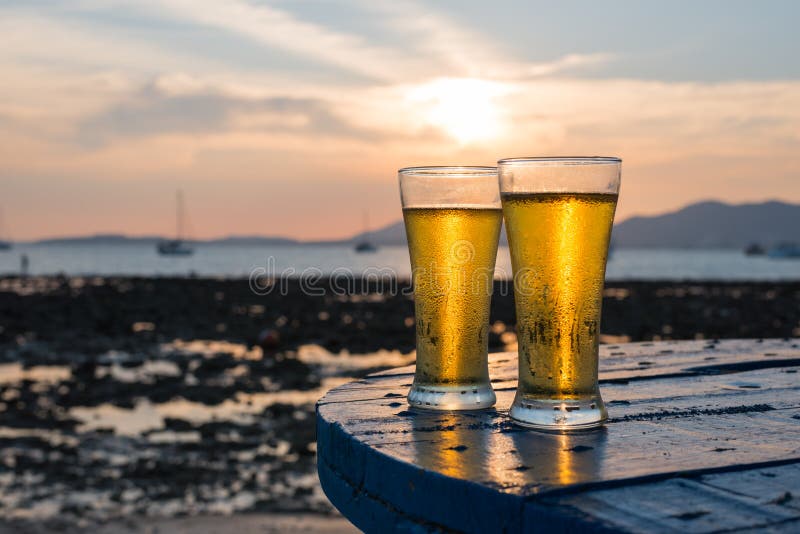 Glass of beer on a sunset stock image. Image of sand - 85585291