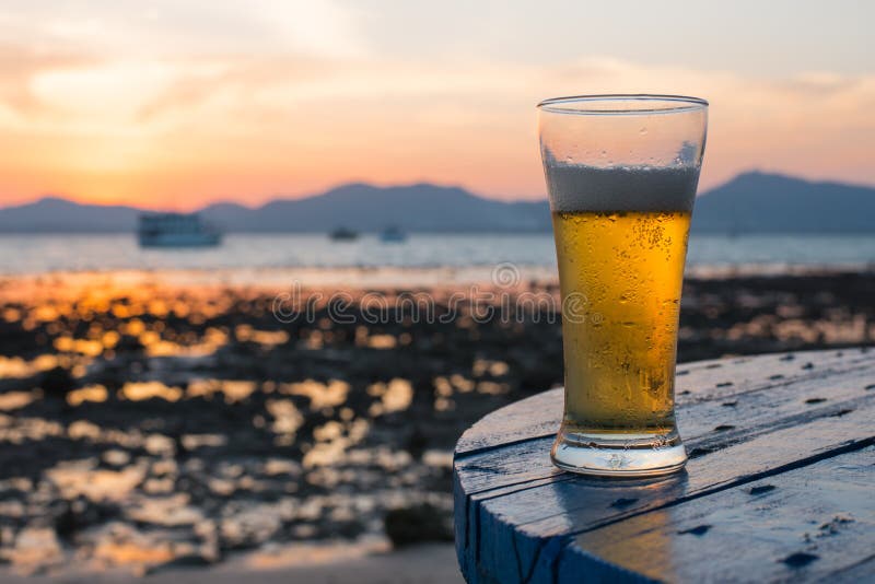Glass of beer on a sunset stock photo. Image of drops - 93775742