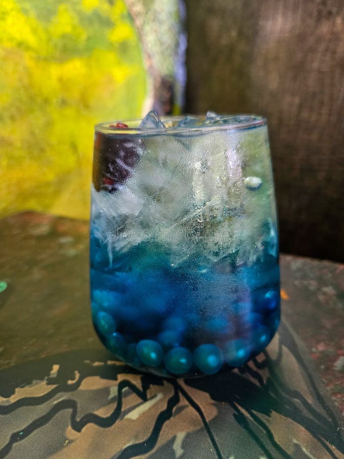 A Glass of Blue Liquid with Ice Cubes in it Stock Photo - Image of ...