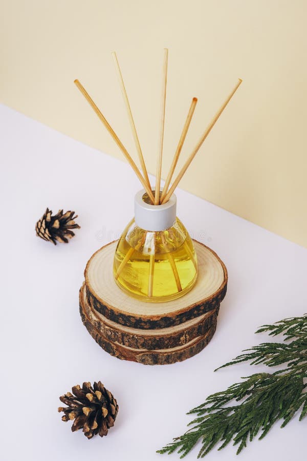 Glass Bottle of Aroma Diffuser and Pine Cones on Wooden Stand on a ...