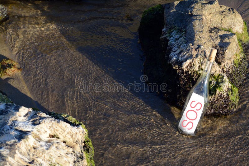 Glass Bottle with SOS Message Near Sea Rocks, Space for Text Stock ...