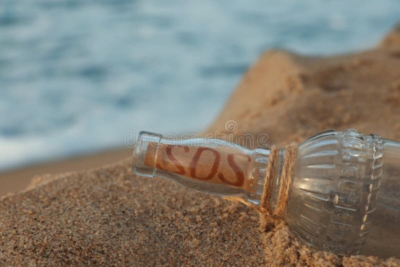 Glass Bottle with SOS Message on Sand Near Sea, Space for Text Stock ...