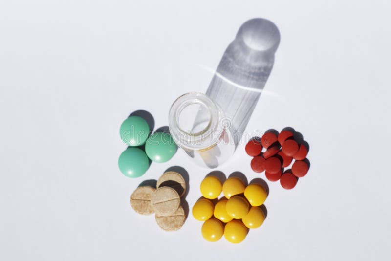 The Glass Bottle for Tablets is Empty, Colored Tablets are Spread ...