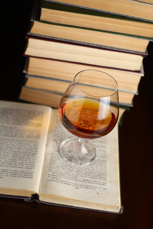 Glass of brandy on books stock photo. Image of taste - 42057484
