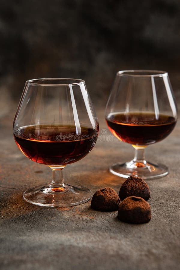 Glass of Brandy or Cognac and Chocolate Truffles on Dark Table Stock ...