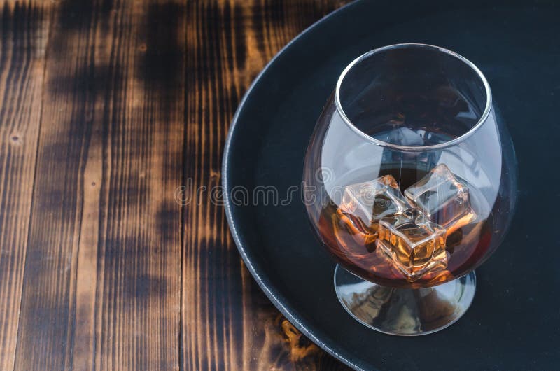 Glass of Brandy with Ice Cubes/Glass of Brandy with Ice Cubes on a ...