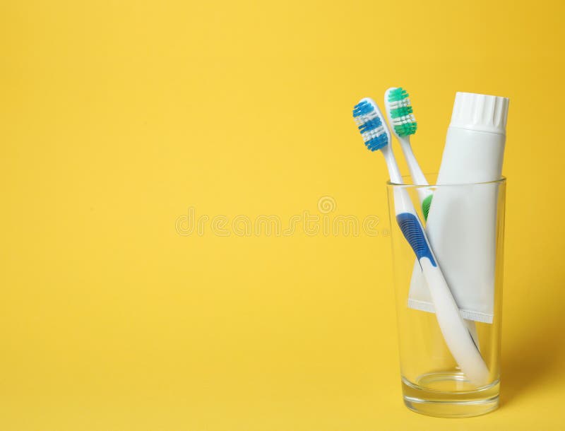 Glass with Brushes and Toothpaste on Color Background. Stock Image ...