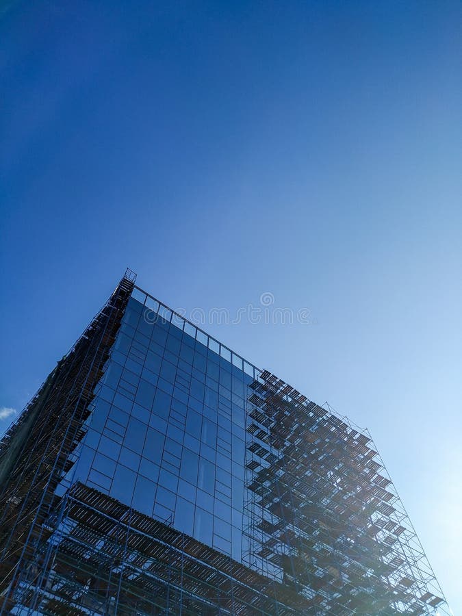 A Glass Building Under Construction. Blue Sky. Construction Stock Photo ...