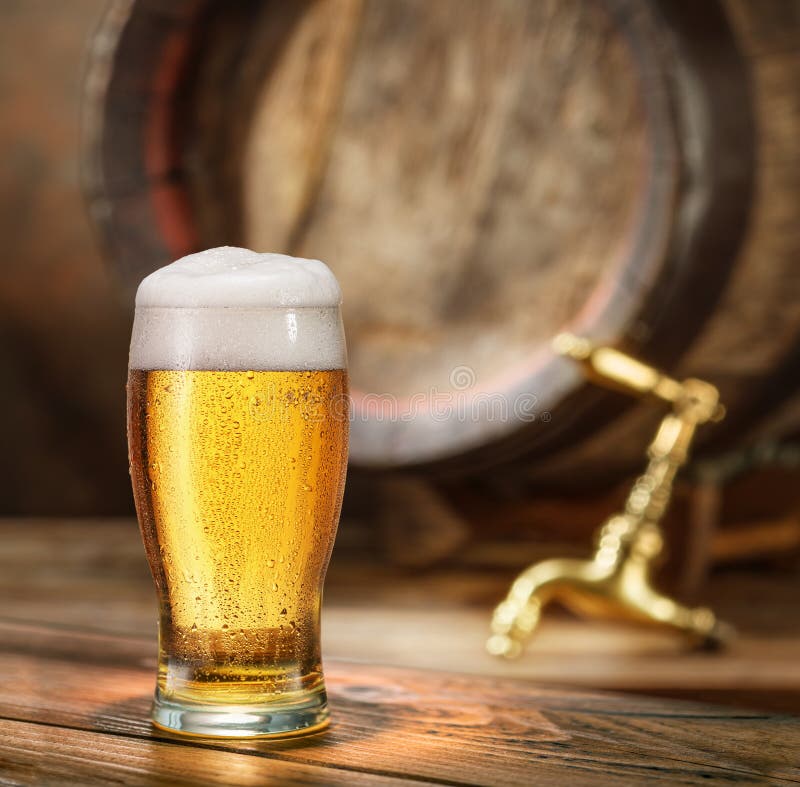 Glass of Chilled Beer and Wooden Beer Cask on the Background Stock ...