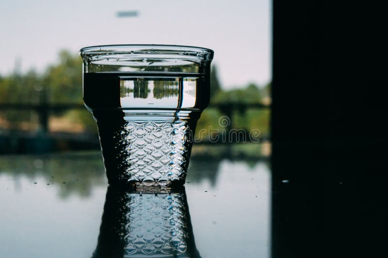 A Glass with Clean Clear Water and Sharp Shadows Stands on a White ...
