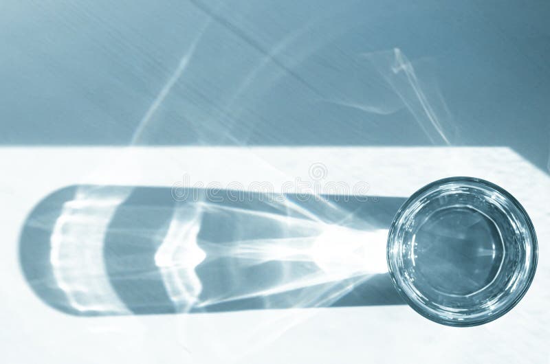 A Glass with Clean Clear Water and Sharp Shadows Stands on a White ...