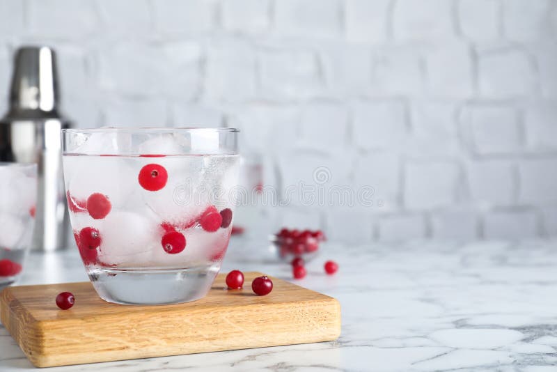 Glass of Cocktail with Vodka, Ice and Cranberry on Marble Table. Space ...