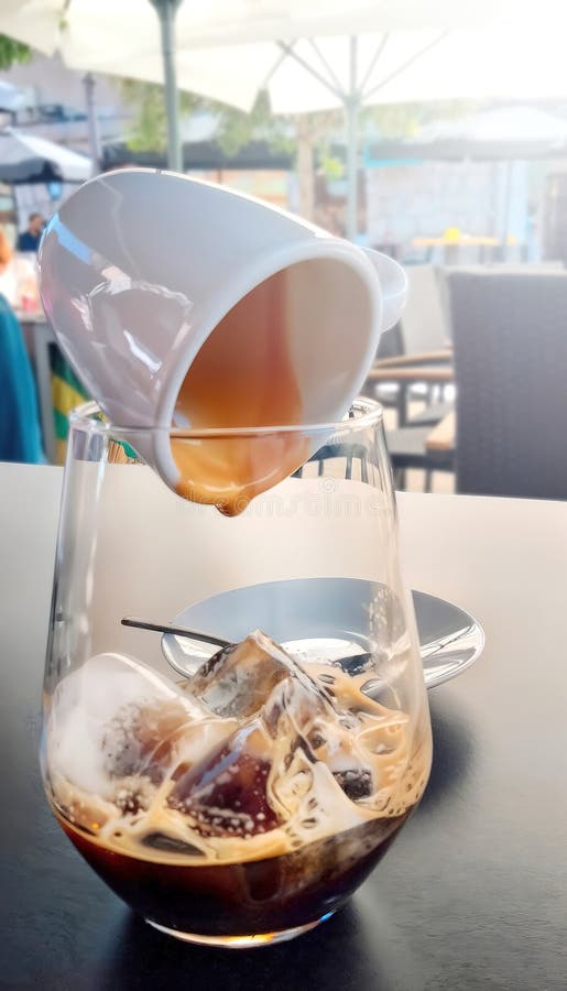A Glass of Coffee with Ice Cubes and a Cup Over it Stock Photo - Image ...