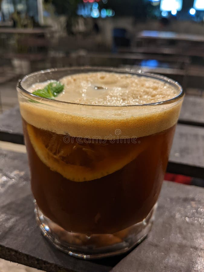 A Glass of Coffee with Slice Orange and Mint on Top of Table in the ...