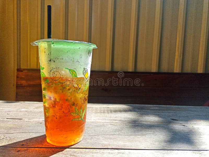 A Glass of Cold Tea in a Plastic Cup after Drinking on a Wooden Table ...