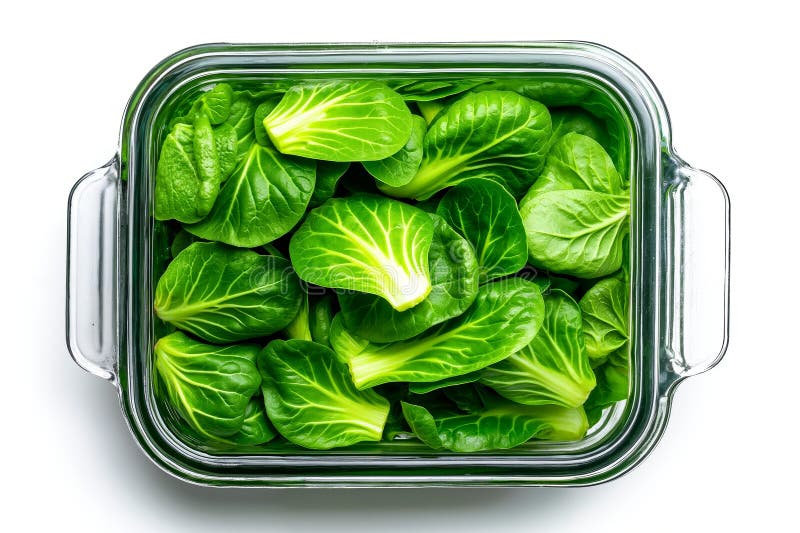 A Glass Container Filled with Green Vegetables on Top of a White ...
