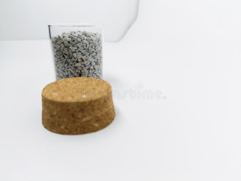 Glass Container with Grey EPDM Rubber Granules and Cork Lid on White ...