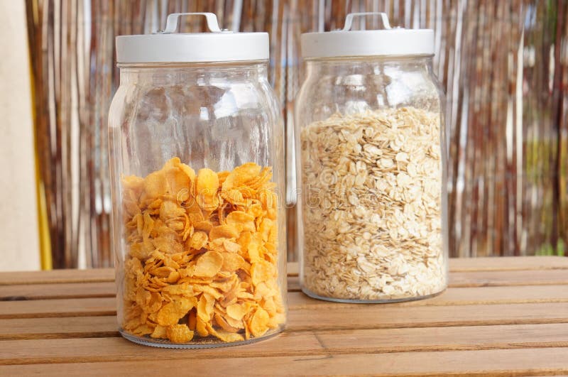 Glass Containers with Corn and Oat Flakes on a Wooden Table Stock Image ...