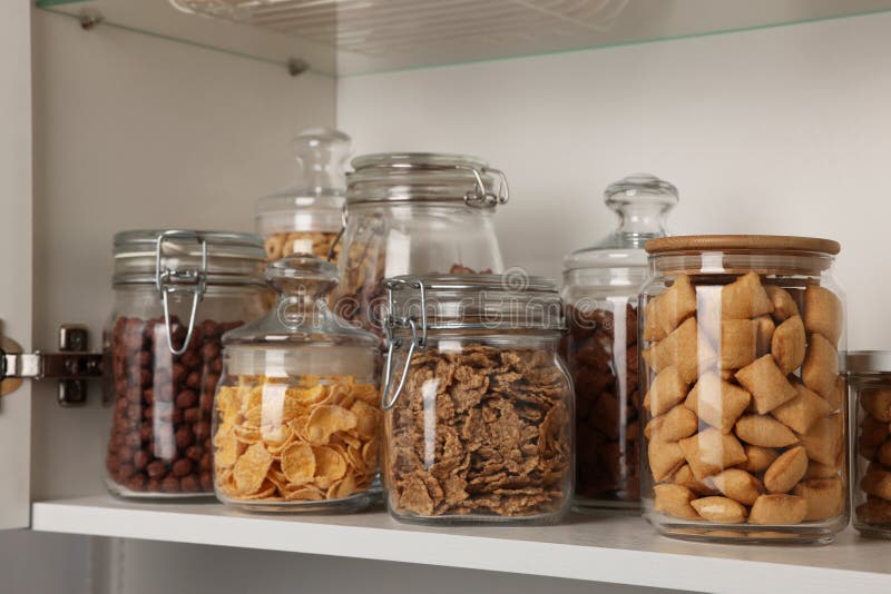 Glass Containers with Different Breakfast Cereals on Shelf Stock Photo ...